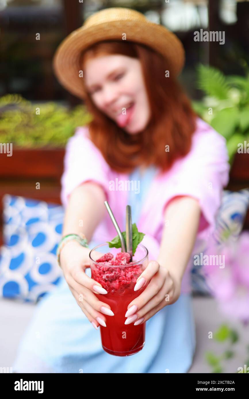 young woman enjoying drinking lemonade while resting in the park on ...
