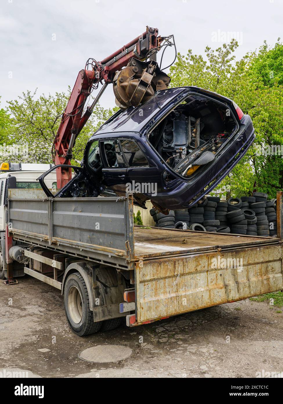Loading an abandoned car wreck using a hydraulic loader crane mounted ...