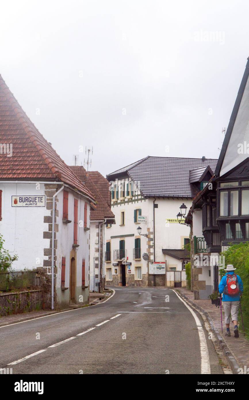 Pilgrim passing through the Spanish village of Burguete while walking ...