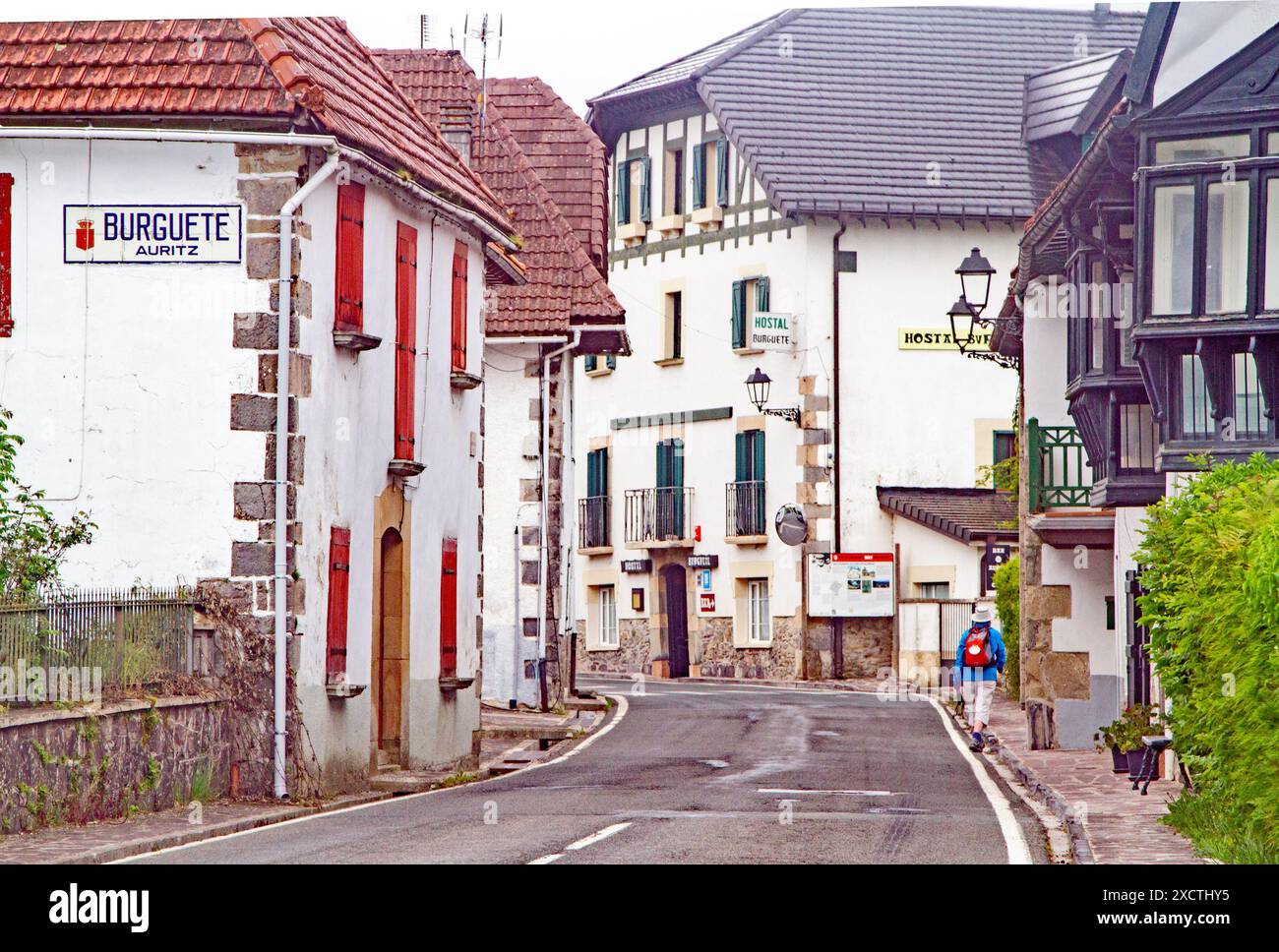 Pilgrim passing through the Spanish village of Burguete while walking ...