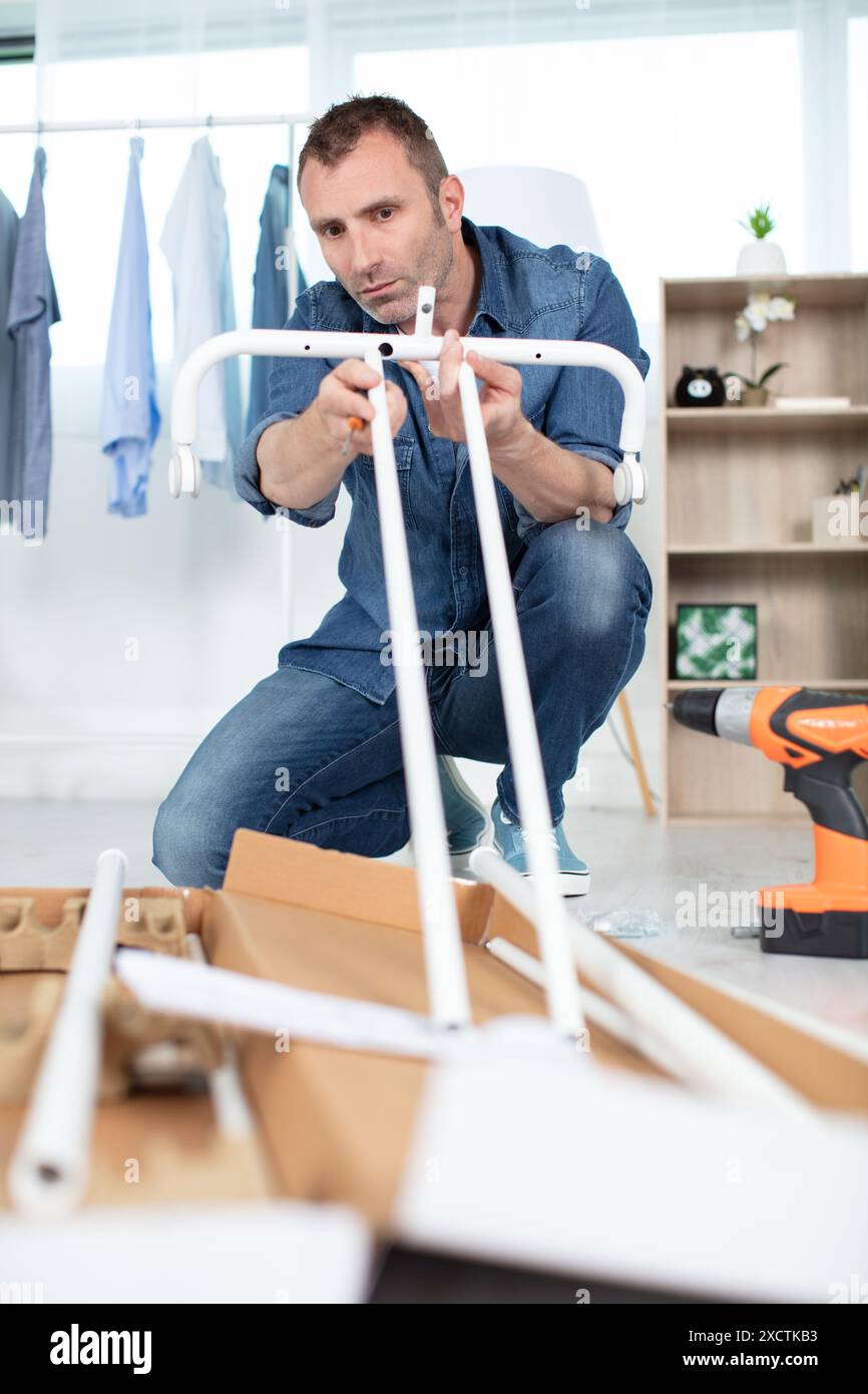 man assembling a metal clothes rail Stock Photo - Alamy