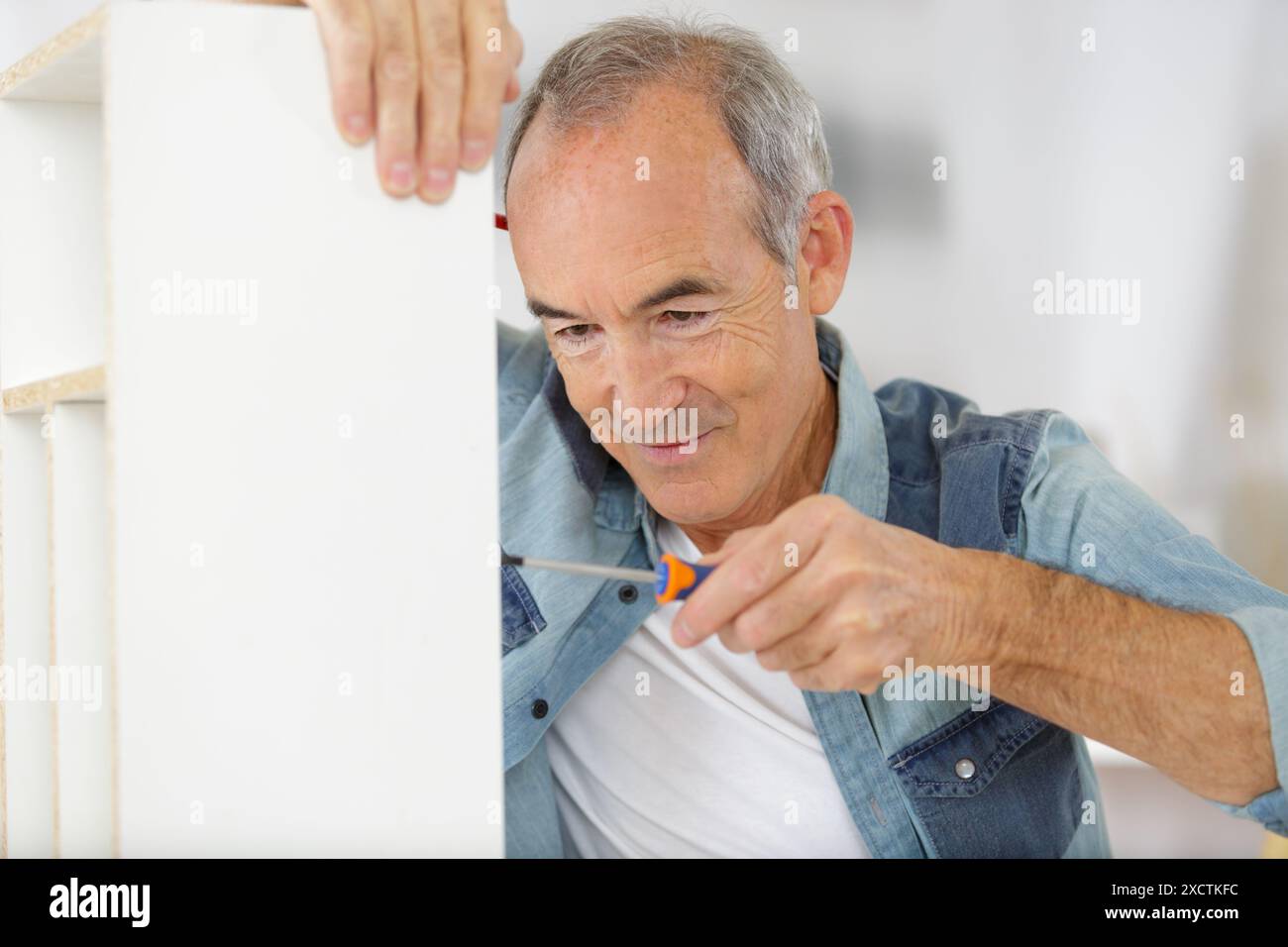 middle aged man working with furniture Stock Photo - Alamy