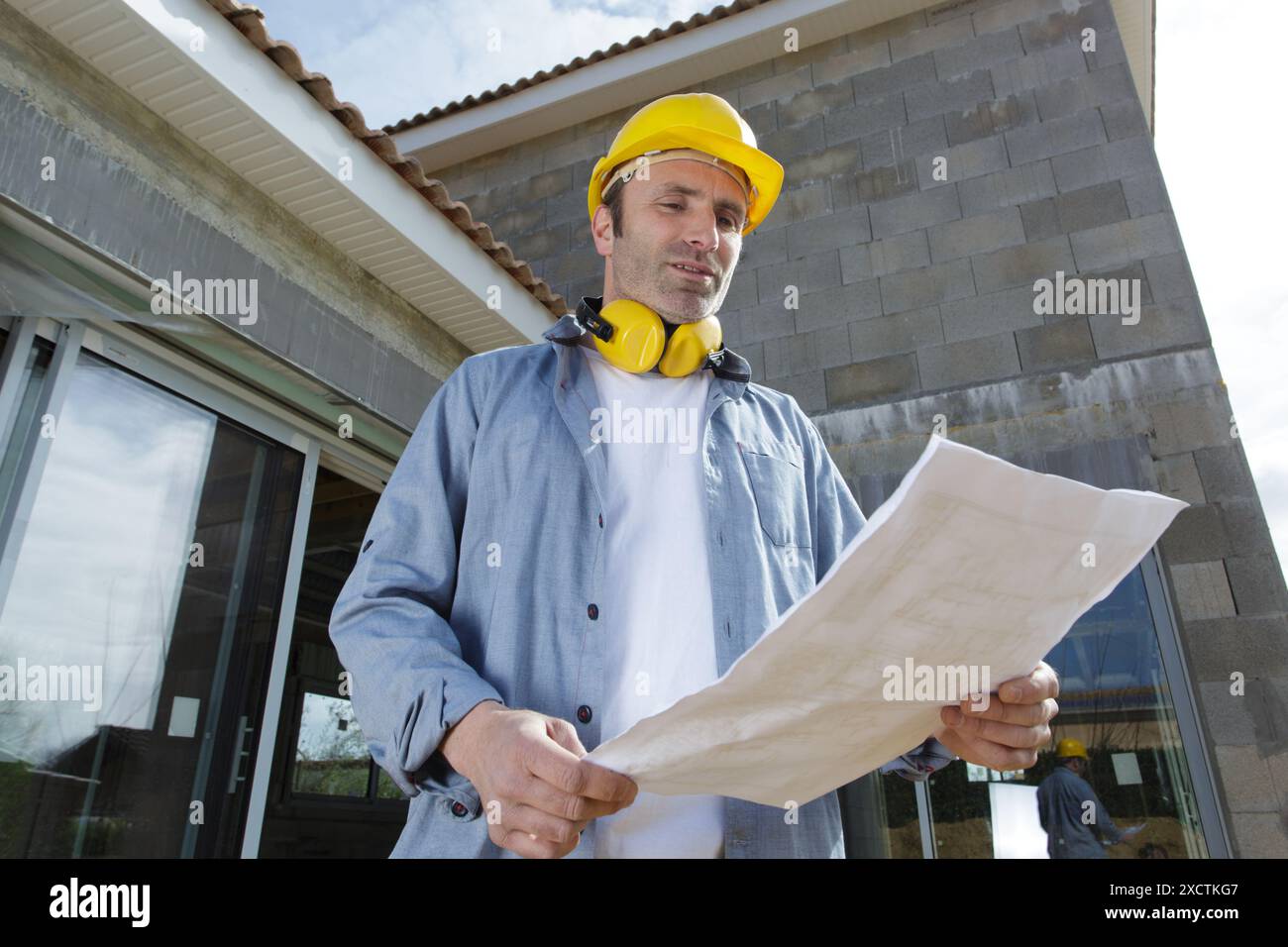 builder is looking at plan outdoor Stock Photo - Alamy