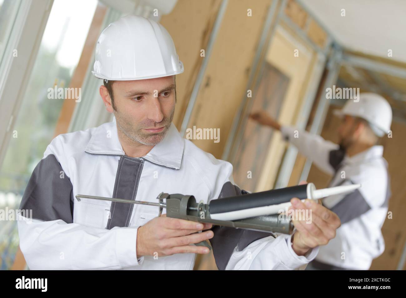 construction worker recharging caulking gun inside new building Stock ...