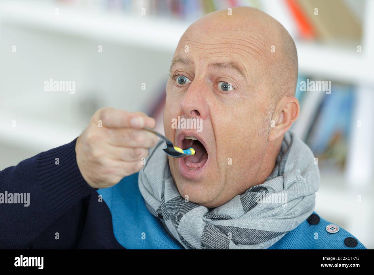 man eating a spoon full of medicine tablets and pills Stock Photo - Alamy
