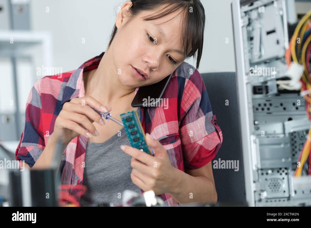 female technician on the phone repairing a computer Stock Photo - Alamy