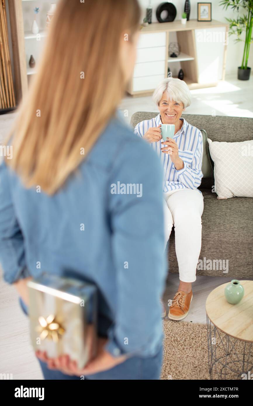 daughter offering a gift to her old mum Stock Photo - Alamy