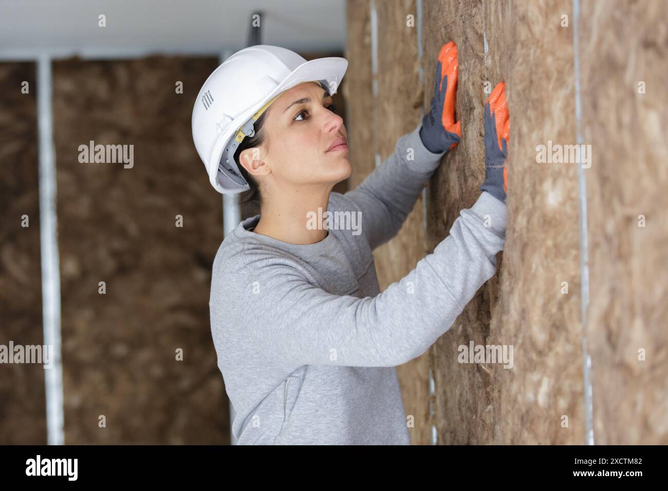 female construction worker installing insulation Stock Photo - Alamy