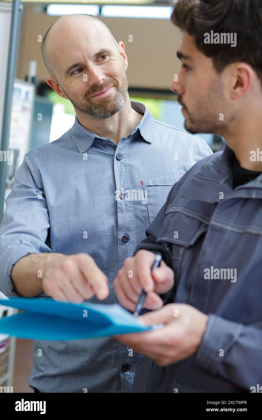 male teacher and student working on class work Stock Photo - Alamy