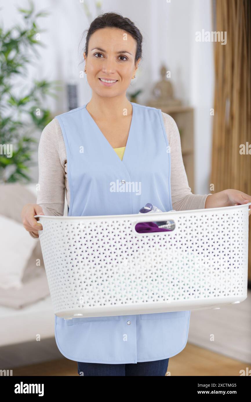 happy worker with folded towels after laundry Stock Photo - Alamy