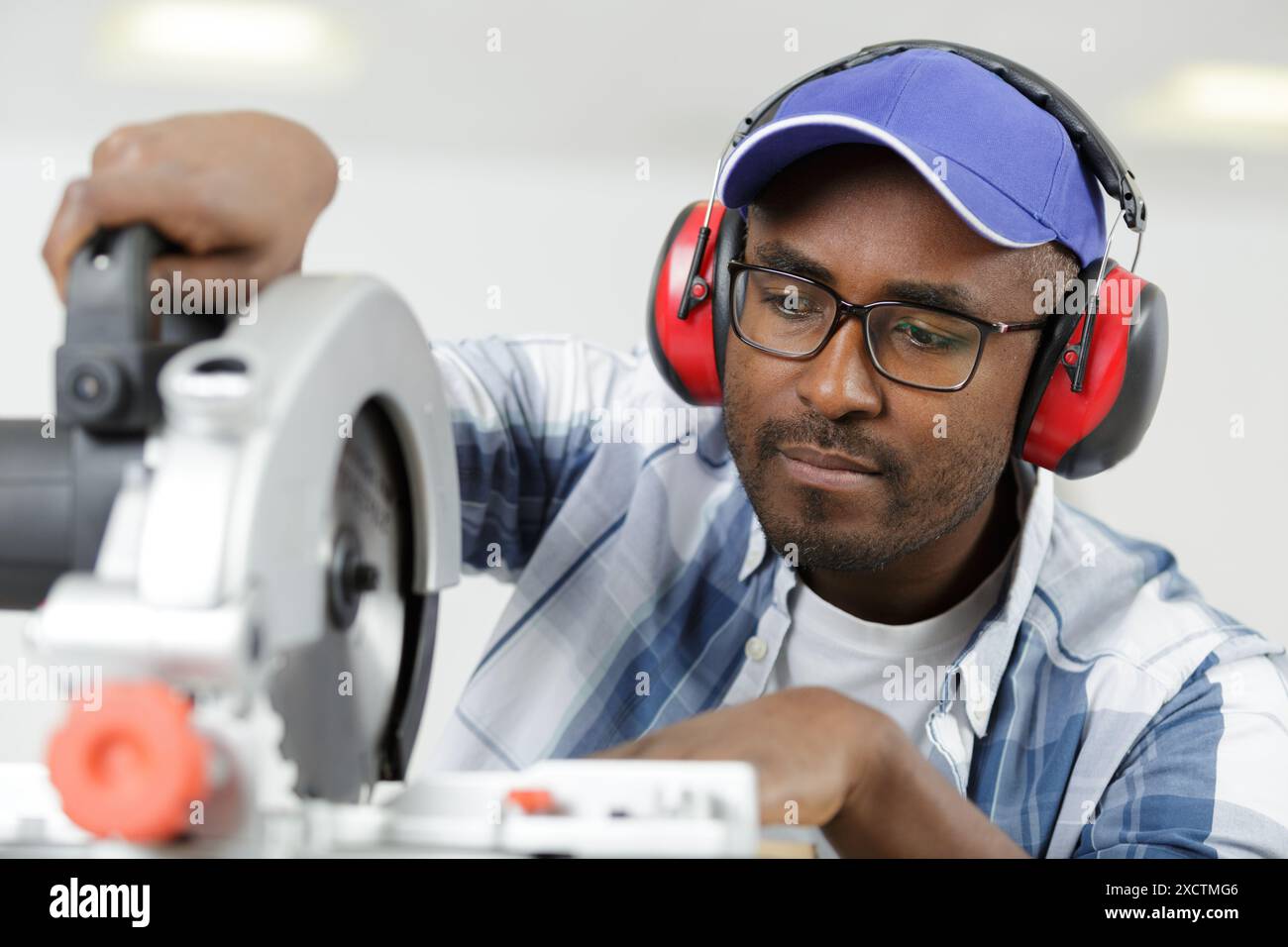young manual worker using grinder on metal in factory Stock Photo - Alamy