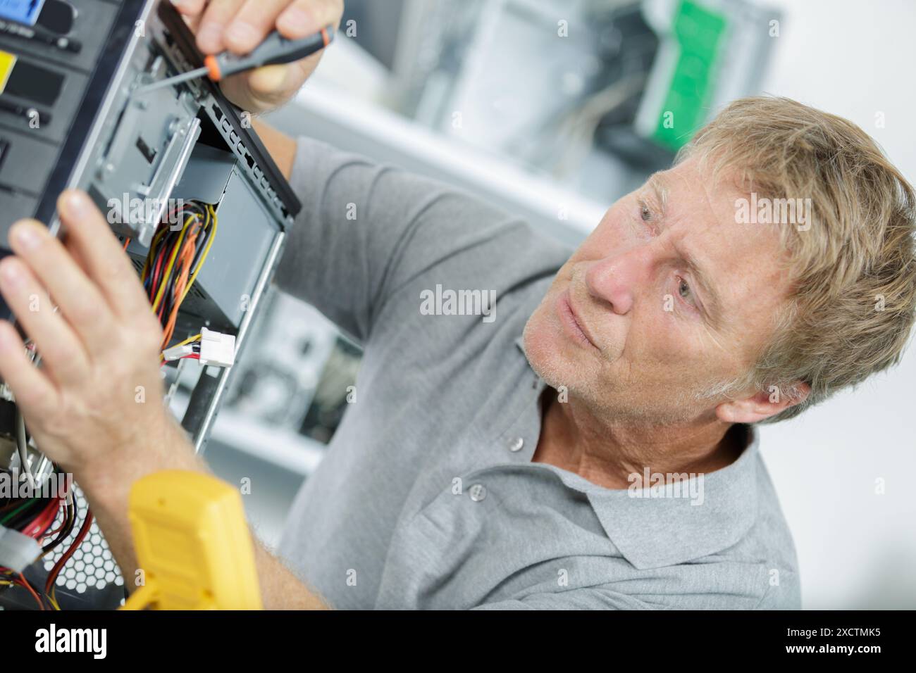 man is repairing broken pc with a screw driver Stock Photo - Alamy