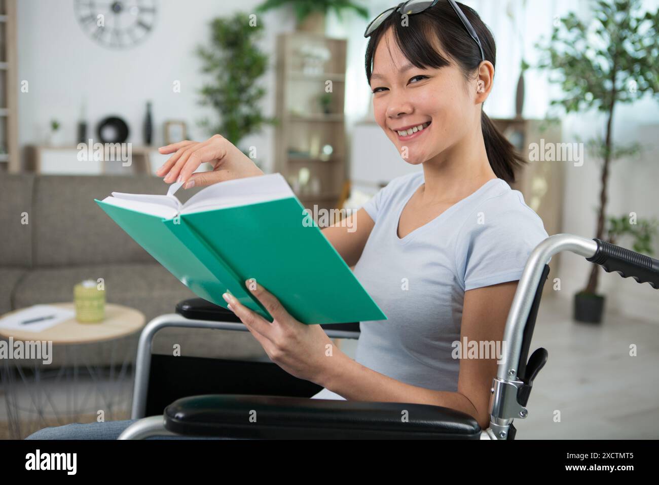 disabled asian woman in wheelchair reading a book Stock Photo - Alamy