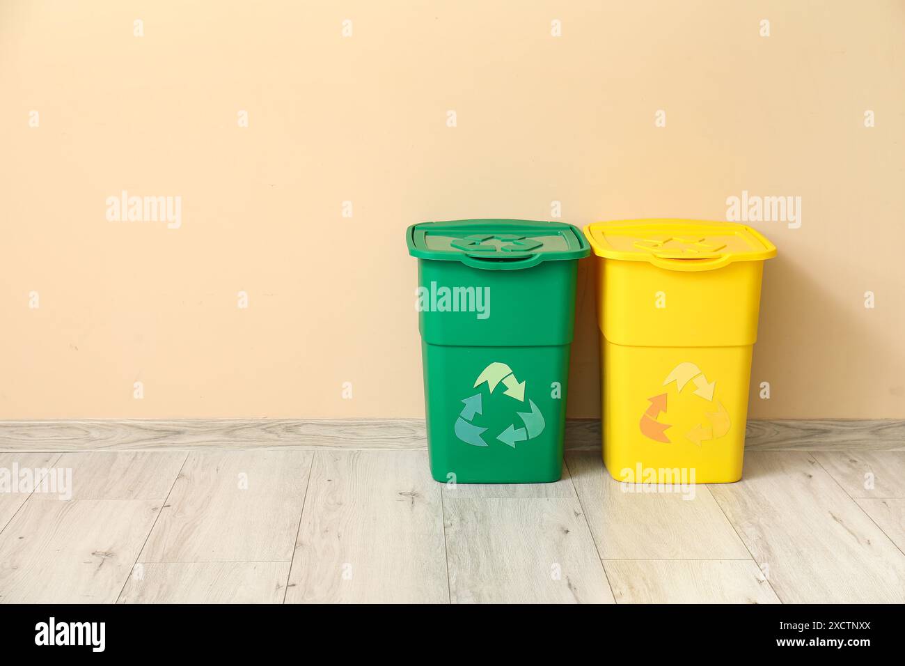 Containers for garbage near beige wall. Recycling concept Stock Photo ...