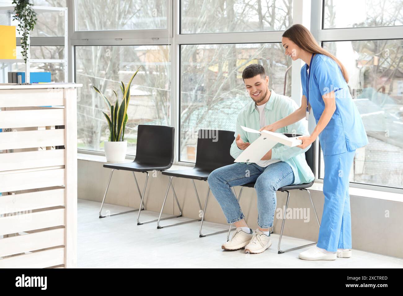 Female receptionist with folder and patient working in clinic Stock ...