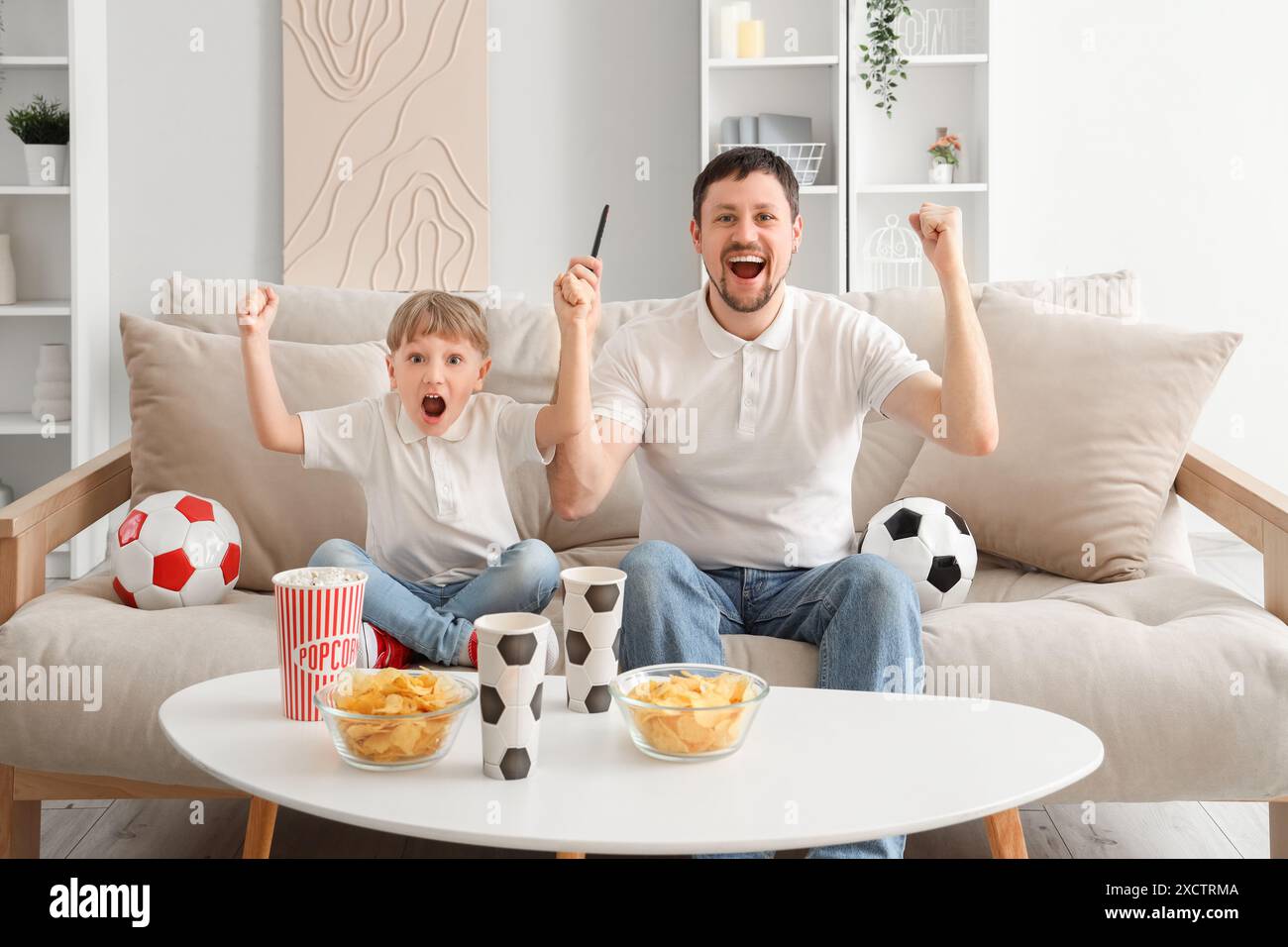 Young father and little son cheering for football team at home Stock ...