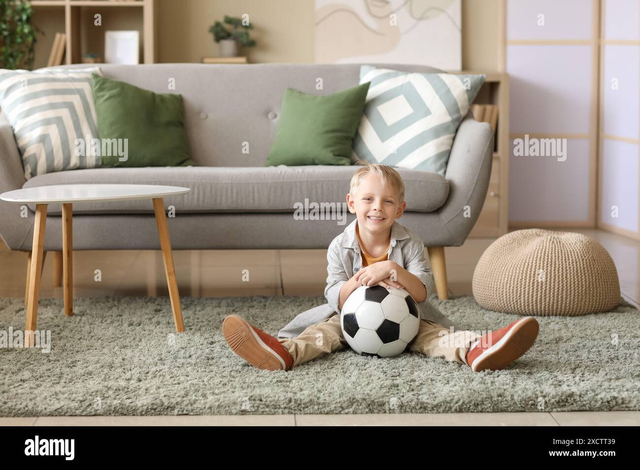 Cute little football player with soccer ball at home Stock Photo - Alamy