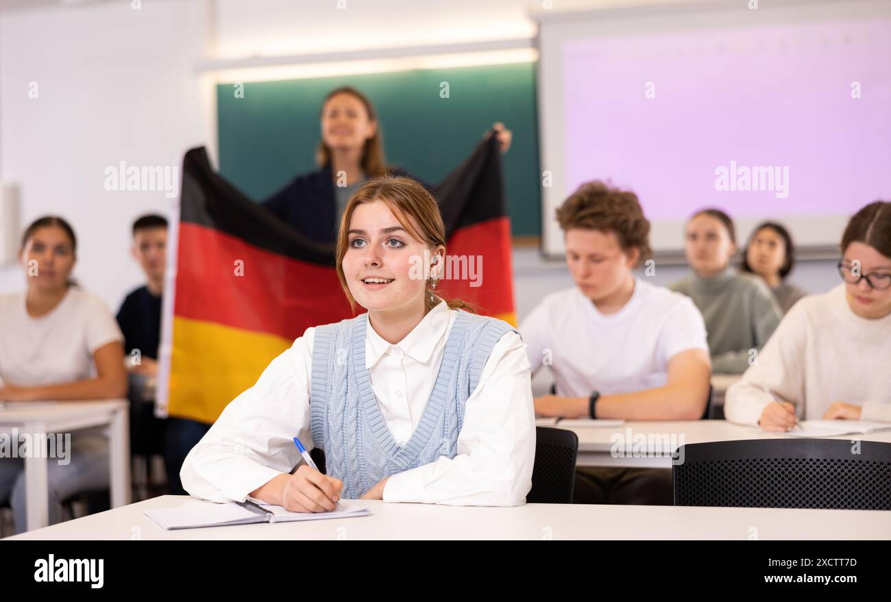 Teacher stands behind students with German flag Stock Photo - Alamy