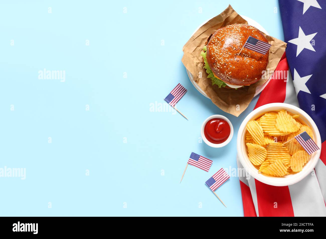 Tasty burger with flags of USA and potato chips on blue background ...