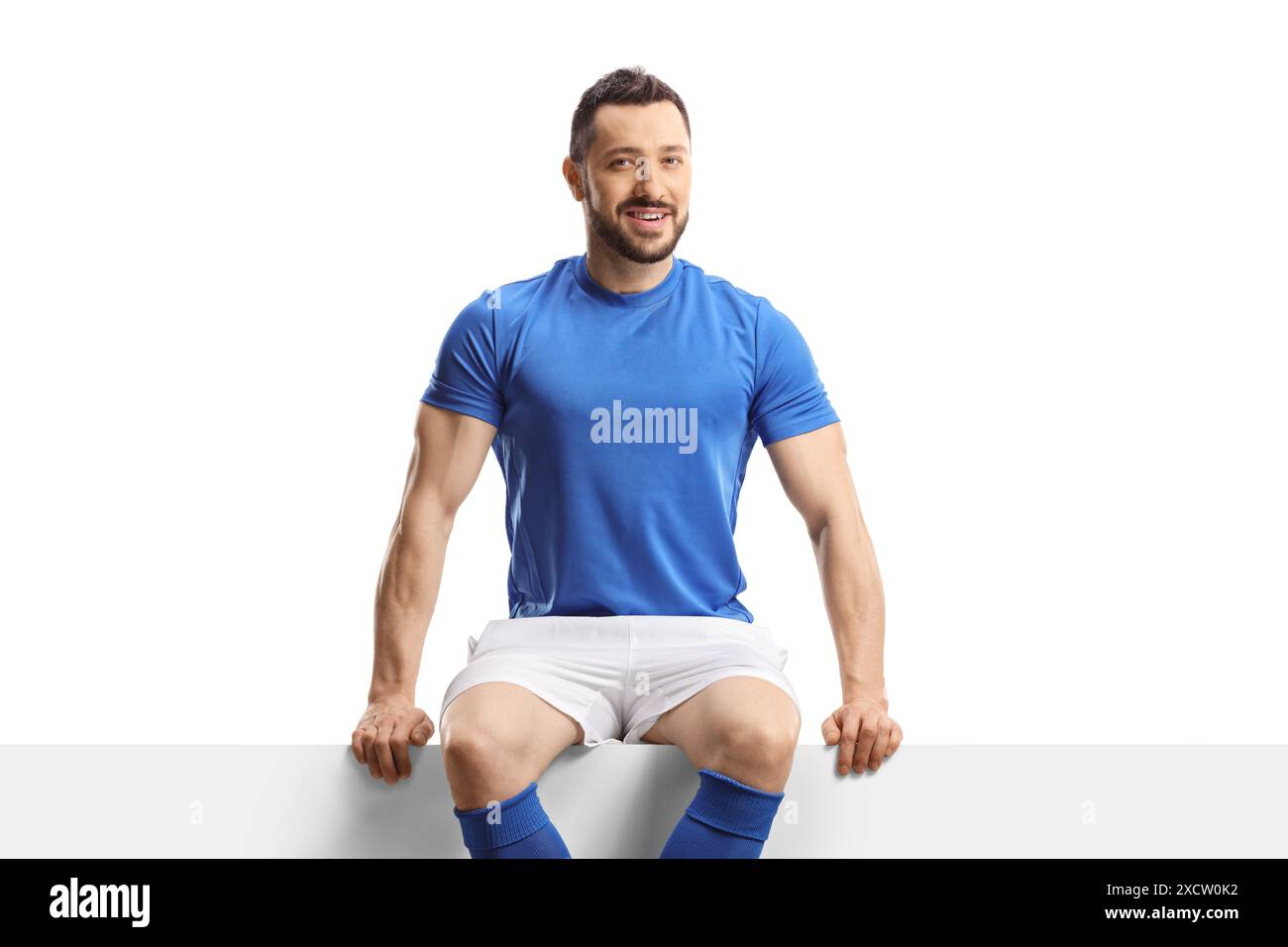 Football player sitting on a blank panel isolated on white background ...
