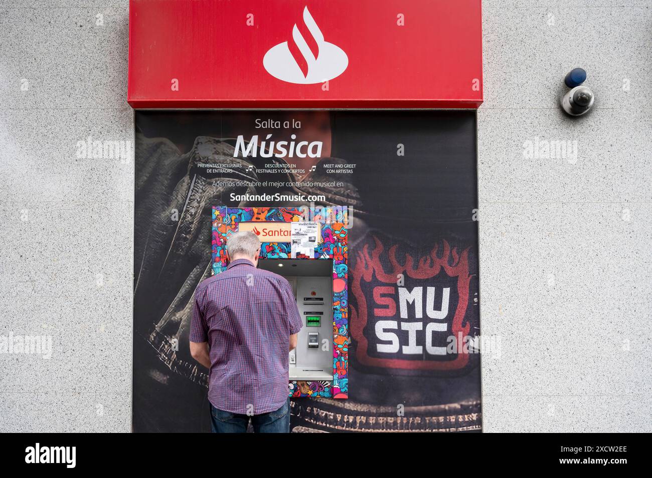 Madrid, Spain. 18th June, 2024. A customer uses the ATM of a Santander ...