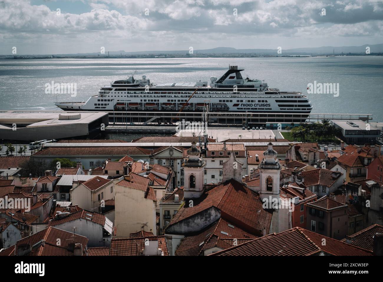 Aerial view of a cruise ship docked at a port with a cityscape of red ...
