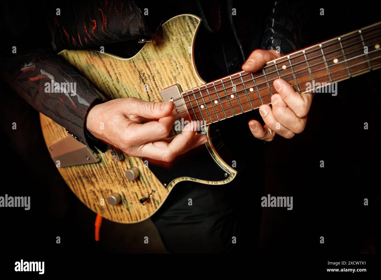 Musician hands playing an electric guitar, intricate finger placement ...