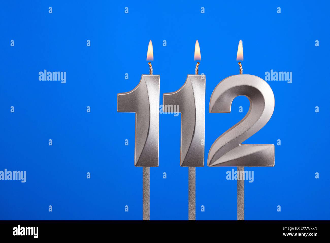 Birthday number 112 - Candle lit on blue background Stock Photo - Alamy
