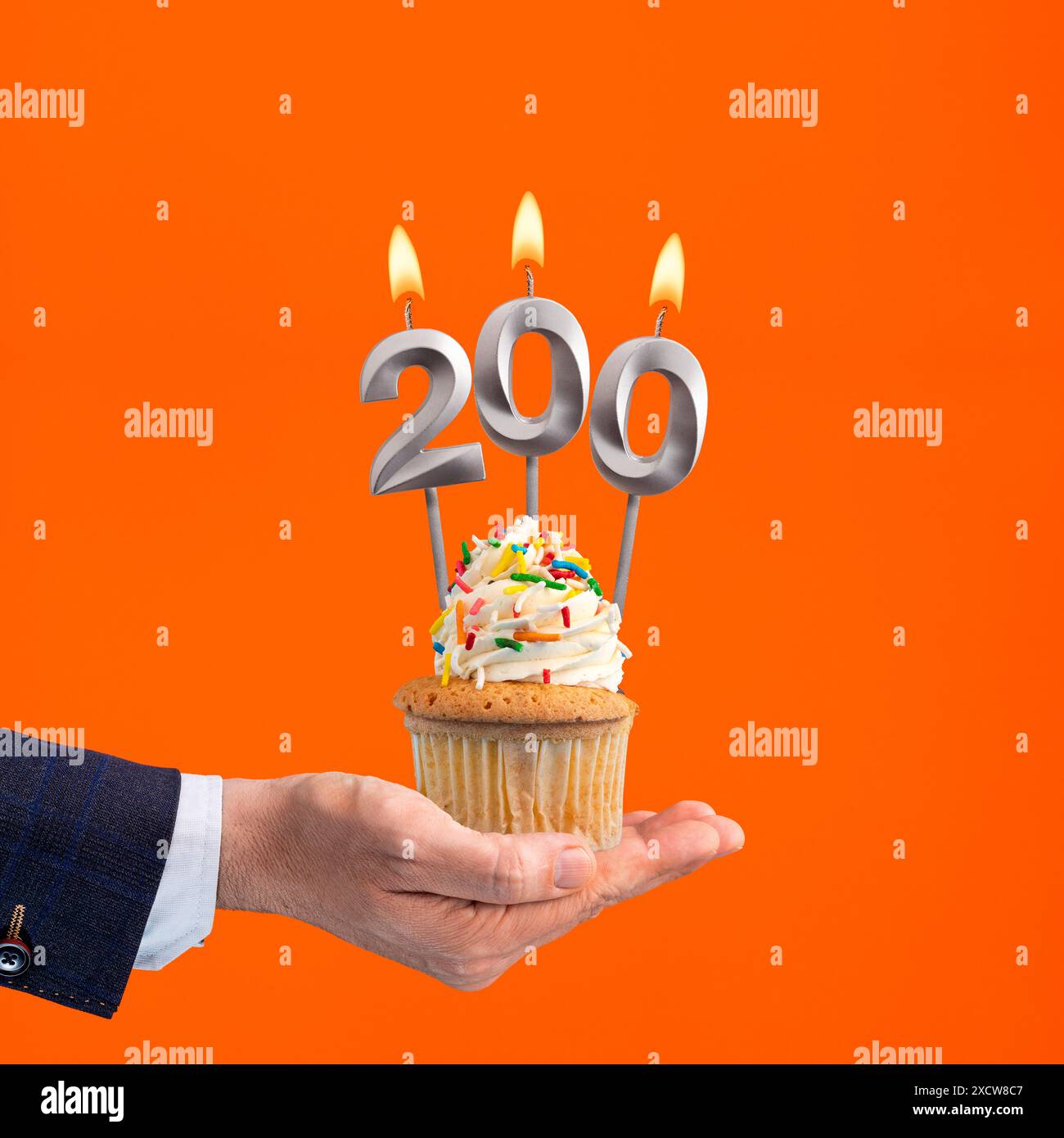 Hand holding birthday cupcake with number 200 candle - background ...