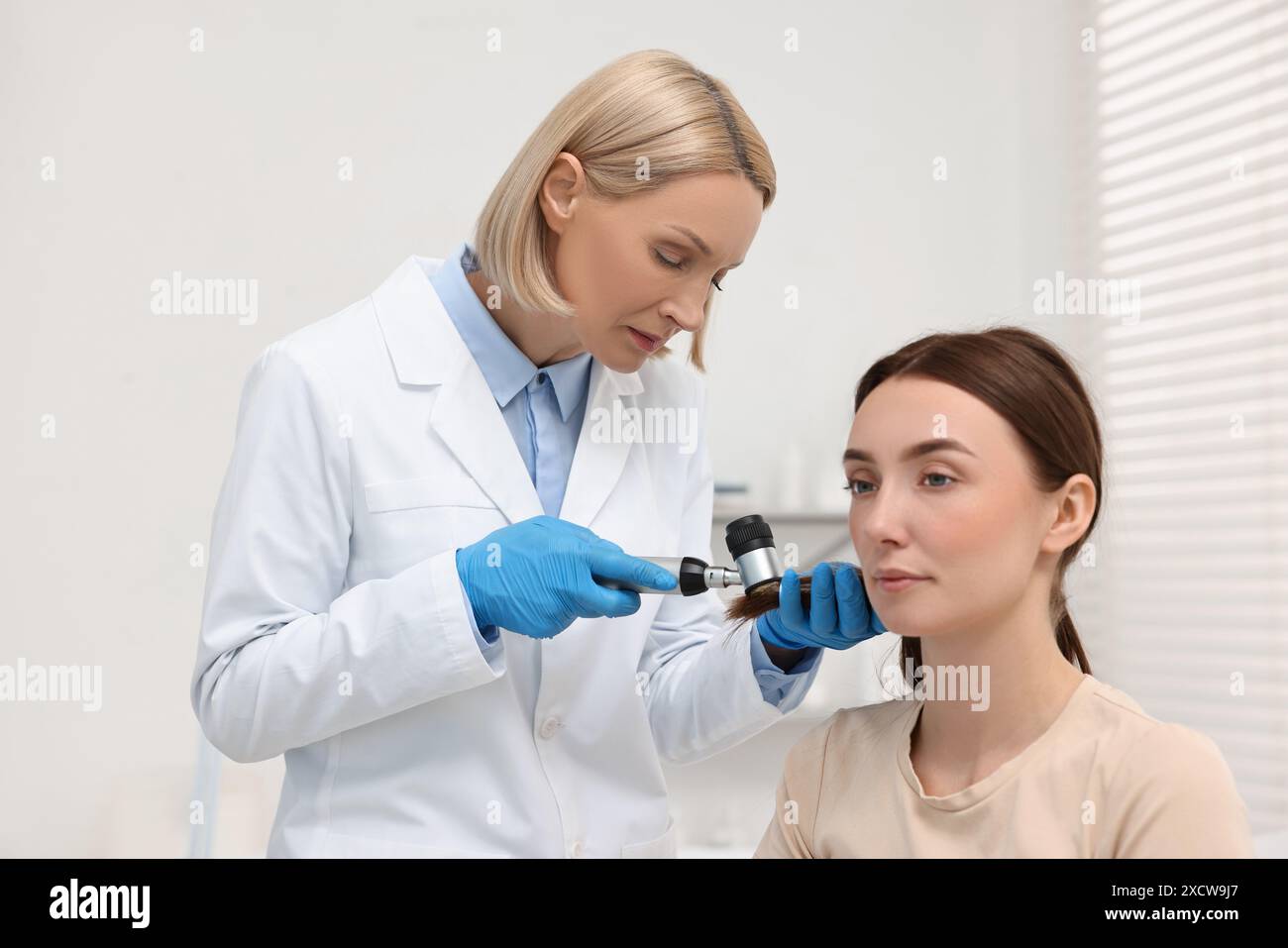 Trichologist with dermatoscope examining patient`s hair in clinic Stock ...