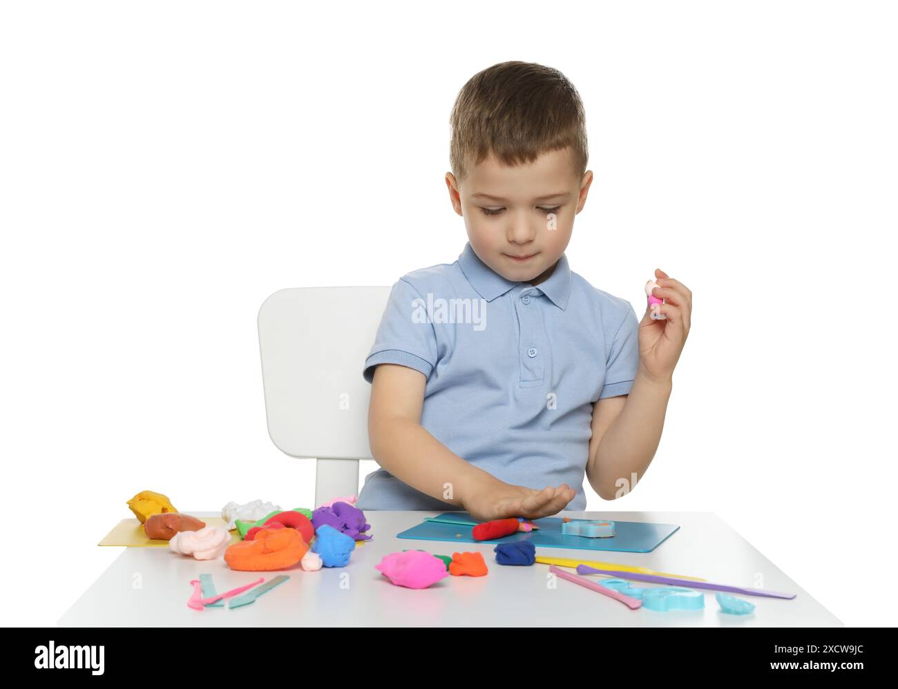 Little boy sculpting with play dough at table on white background Stock ...
