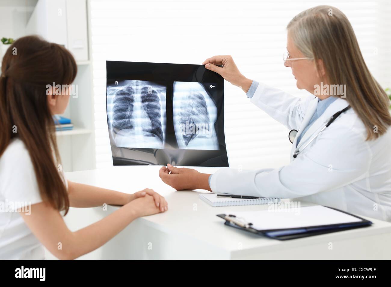 Lung disease. Doctor showing chest x-ray to her patient in clinic Stock ...