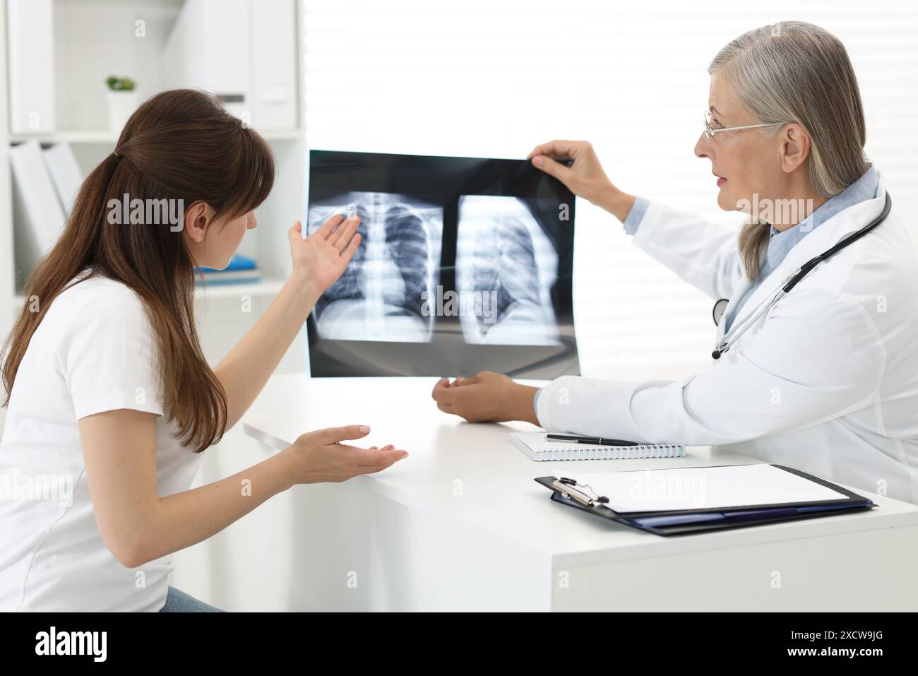 Lung disease. Doctor showing chest x-ray to her patient in clinic Stock ...