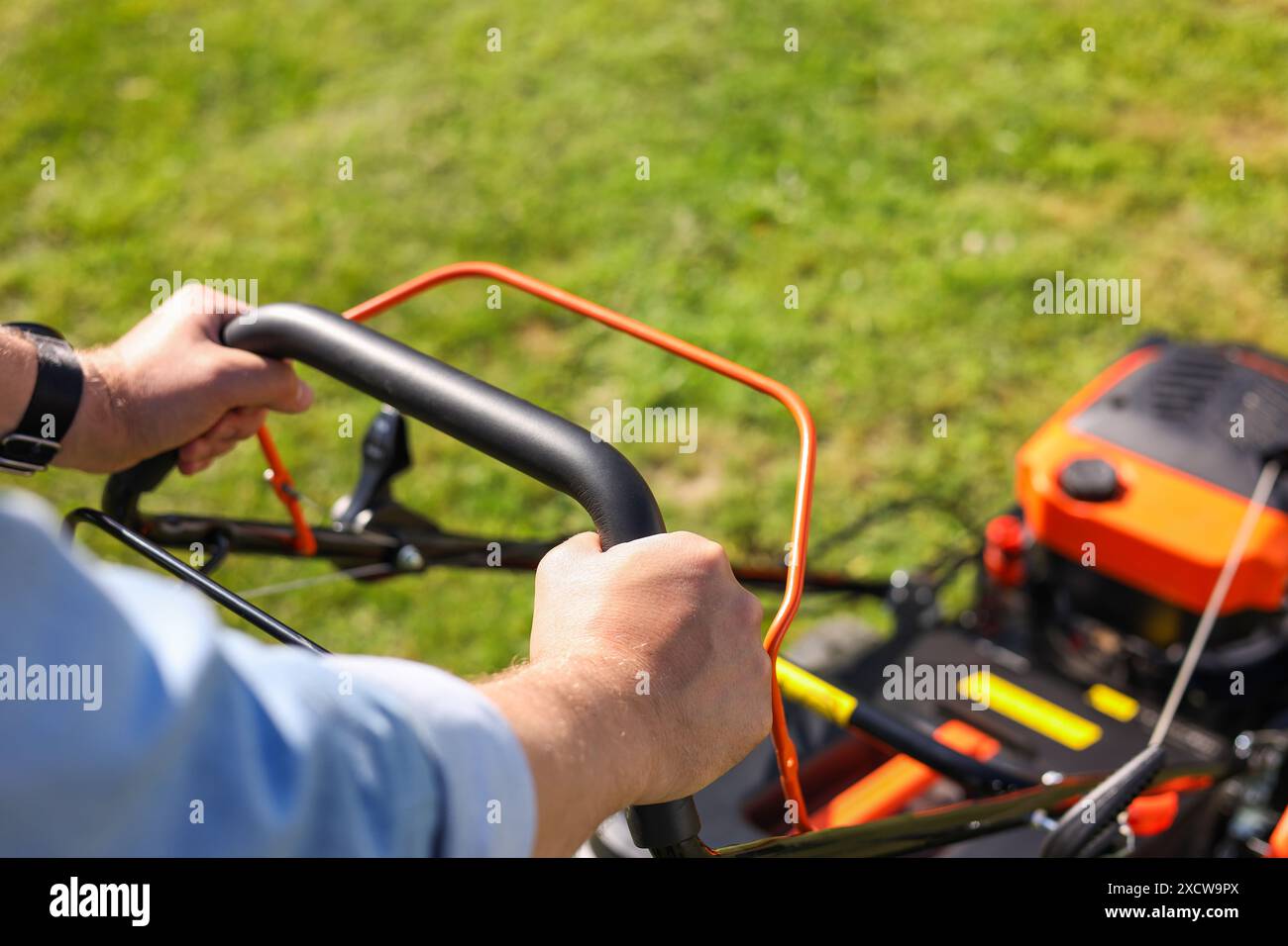 Man cutting grass with lawn mower outdoors, closeup Stock Photo - Alamy