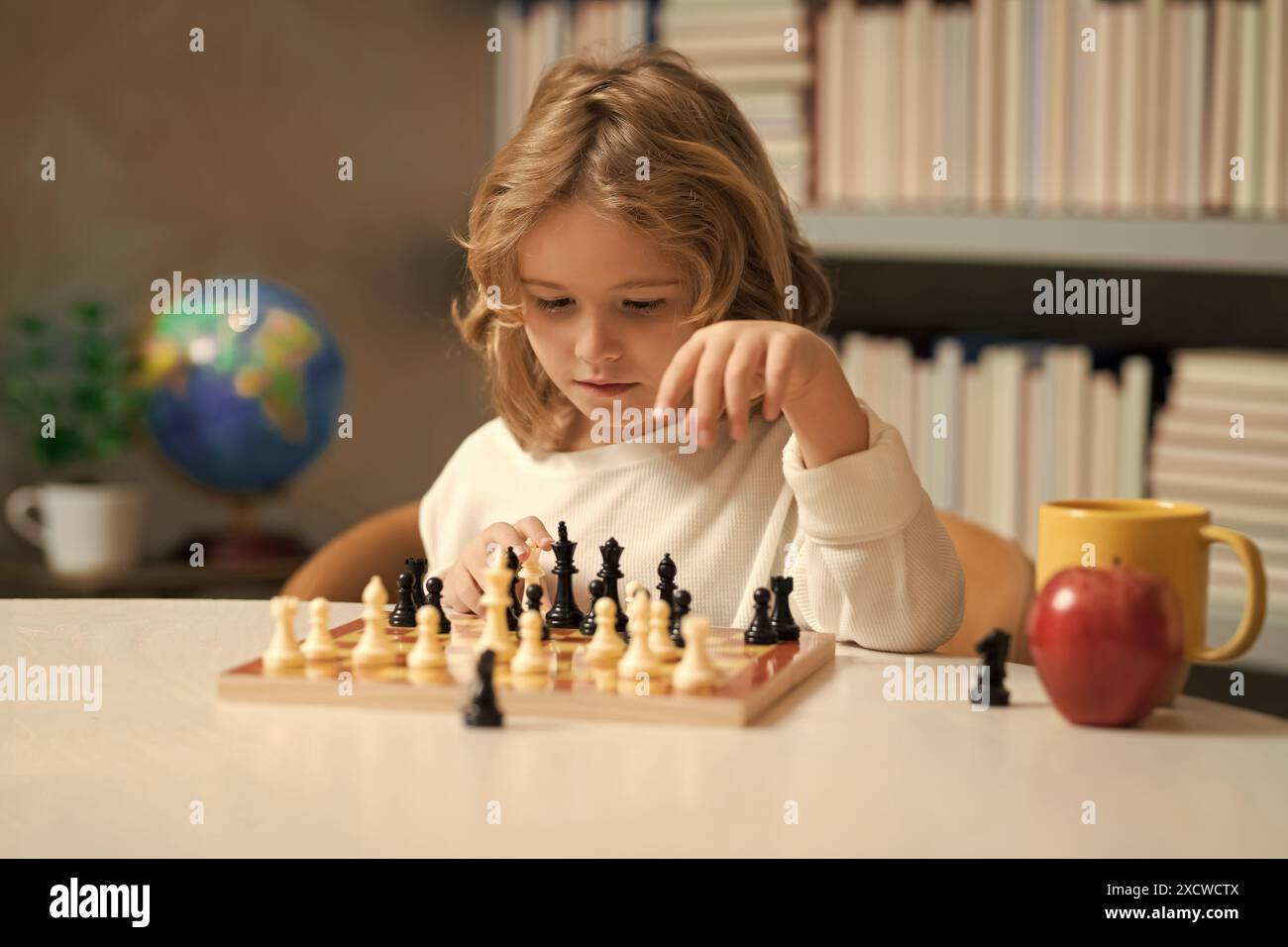 Clever concentrated and thinking child playing chess. Logic game for ...