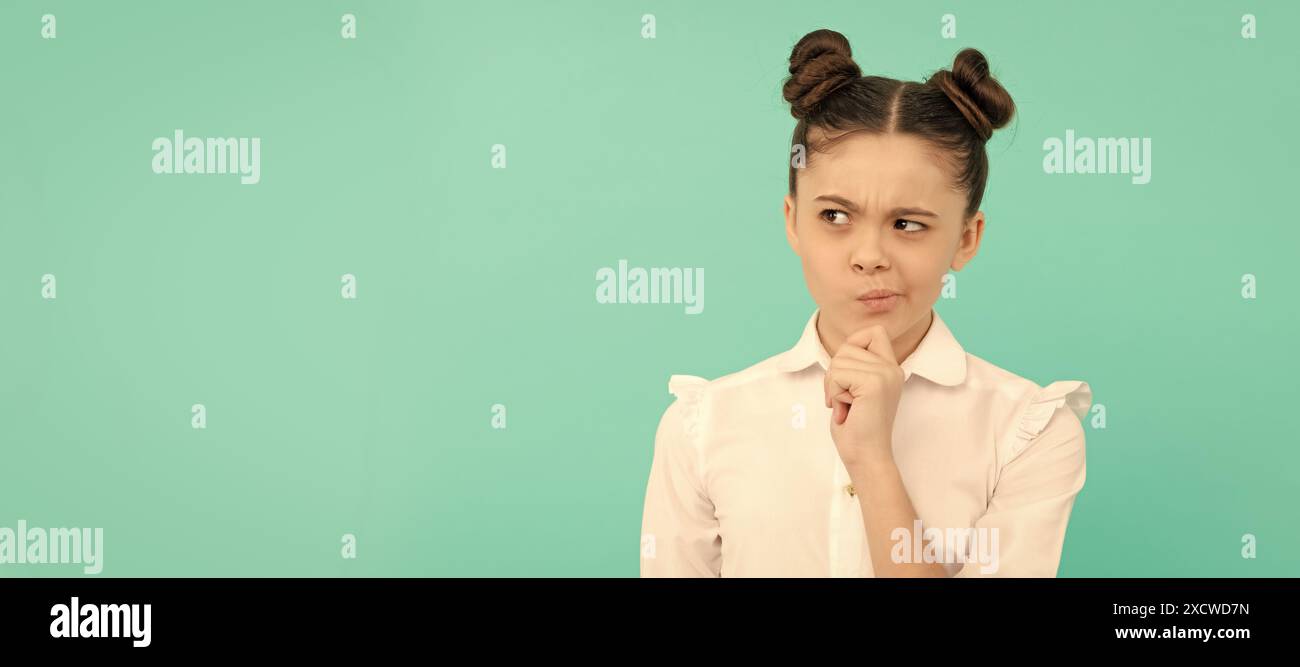 Thoughtful elementary school child think looking away blue background ...