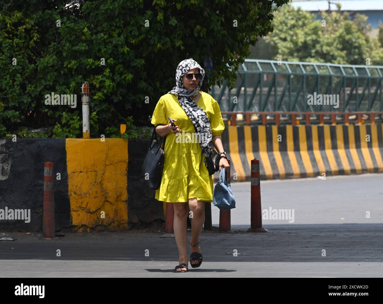 NOIDA, INDIA - JUNE 18: Commuters cover their heads to escape the heat ...