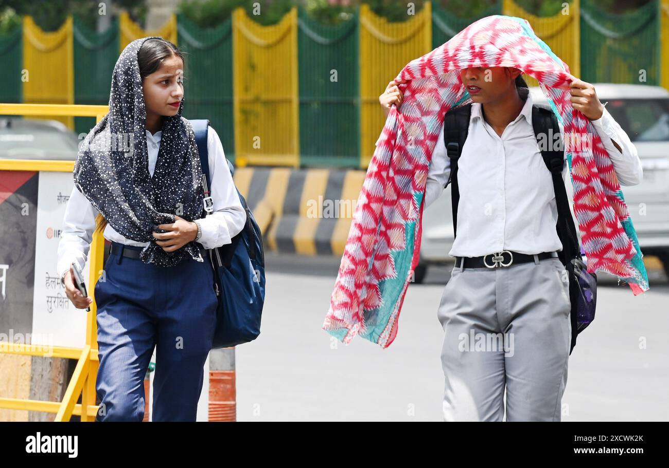 NOIDA, INDIA - JUNE 18: Commuters cover their heads to escape the heat ...