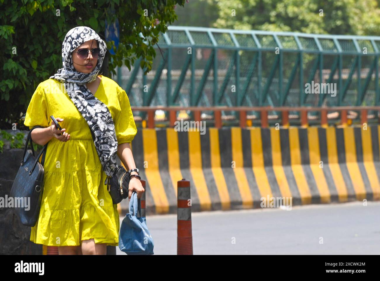 NOIDA, INDIA - JUNE 18: Commuters cover their heads to escape the heat ...