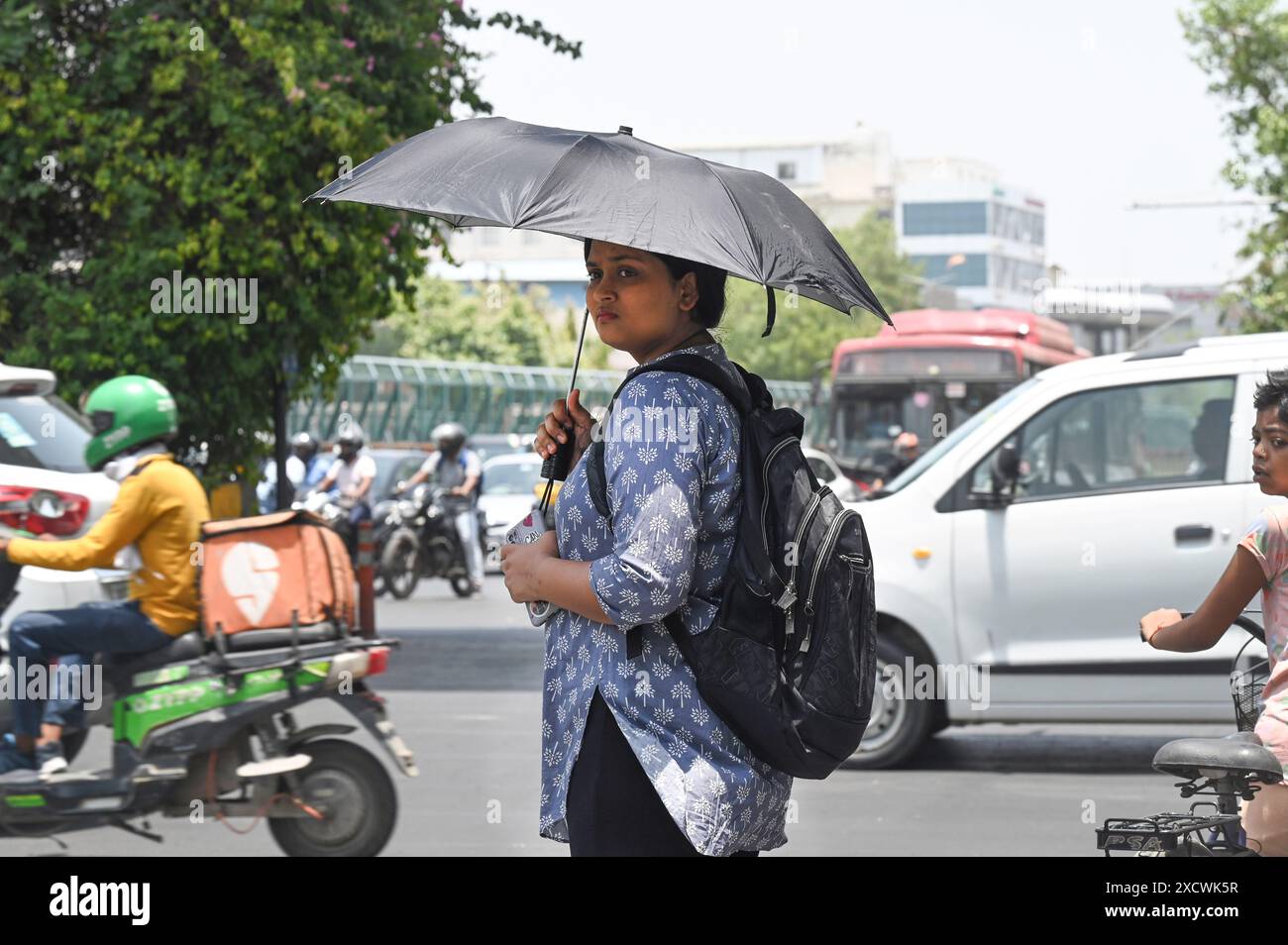NOIDA, INDIA - JUNE 18: Commuters cover their heads to escape the heat ...