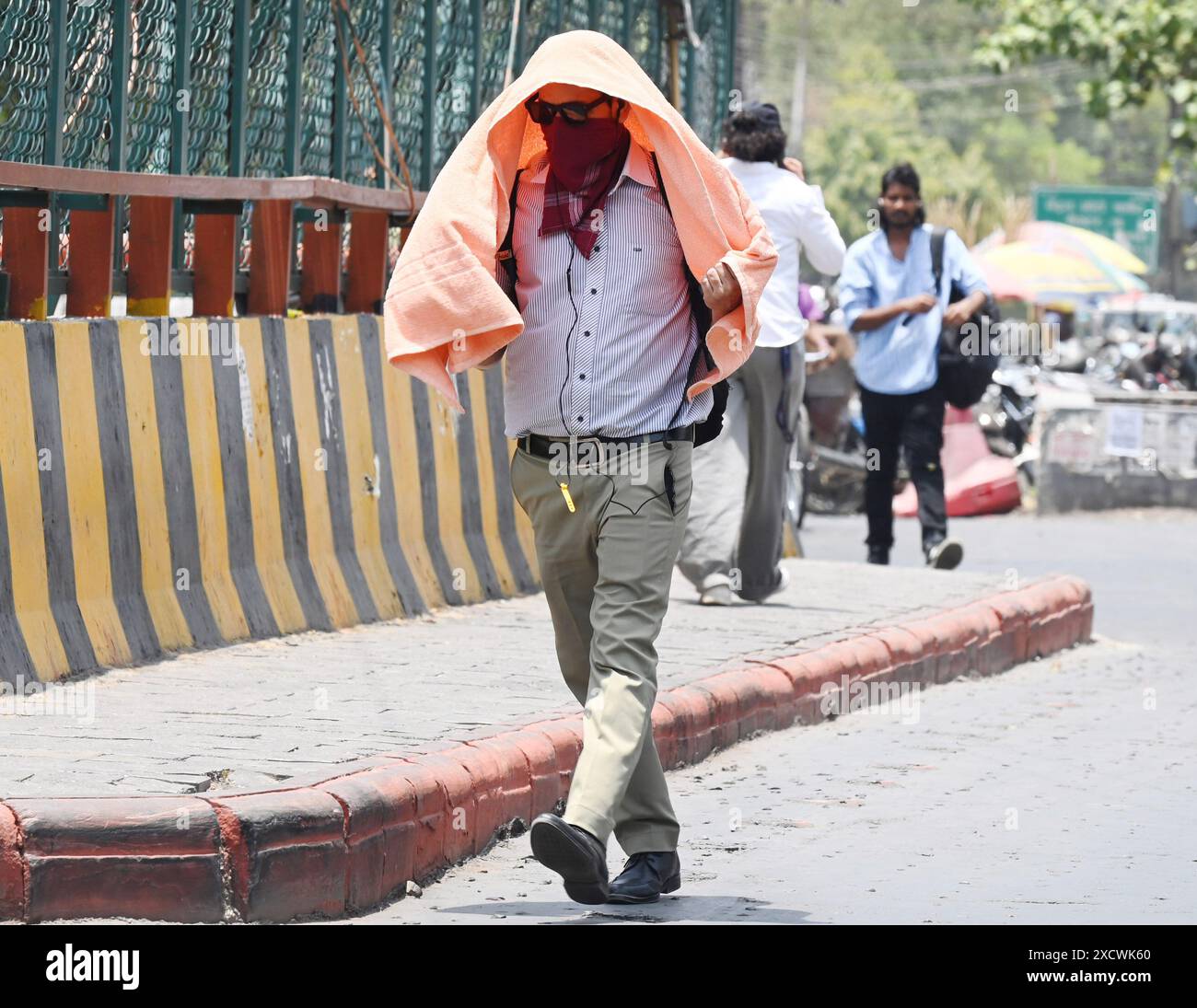 NOIDA, INDIA - JUNE 18: Commuters cover their heads to escape the heat ...