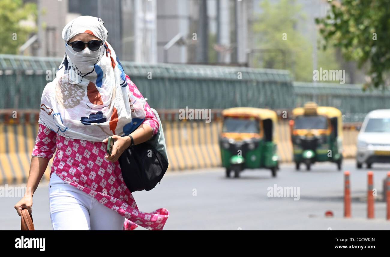 NOIDA, INDIA - JUNE 18: Commuters cover their heads to escape the heat ...