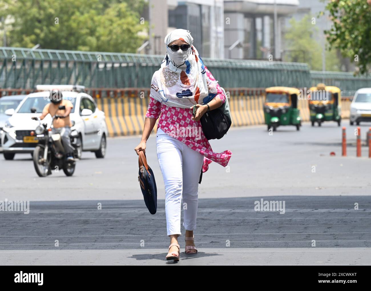NOIDA, INDIA - JUNE 18: Commuters cover their heads to escape the heat ...