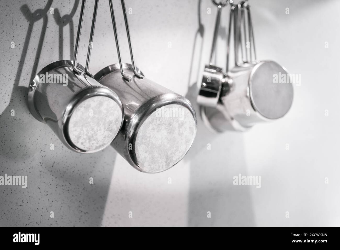 Stainless Steel Cooking Pots Hanging On A White Wall Stock Photo - Alamy