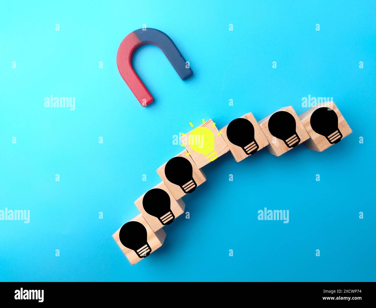 A magnet attracts a glowing idea light bulb. Choosing fresh idea ...