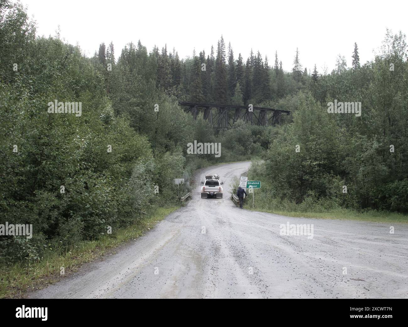 Truck driving over small bridge with an old train bridge in the ...