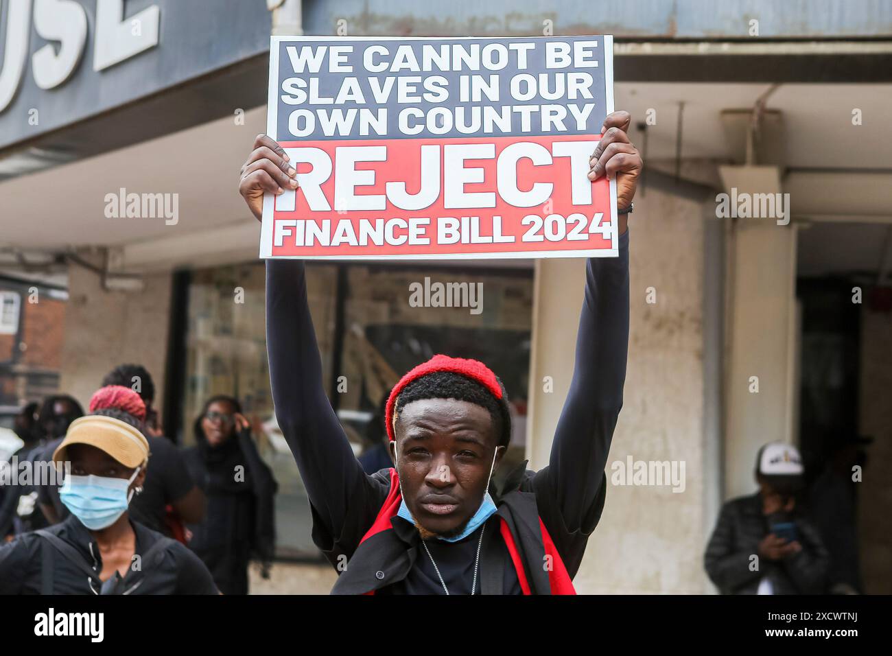 Nairobi, Kenya. 18th June, 2024. A Protester holds a placard during a ...