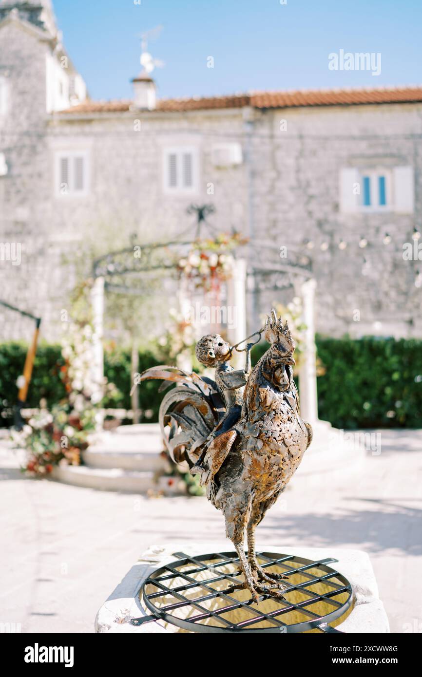 Sculpture of a bugler boy riding a rooster in the courtyard of an ...