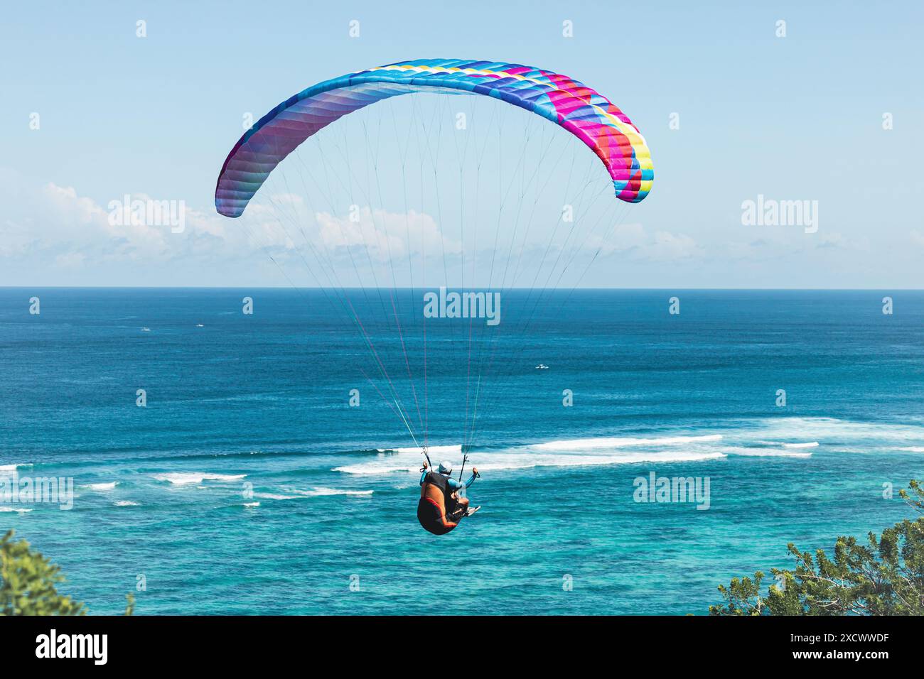 Paraglider flies in front of the ocean Stock Photo - Alamy