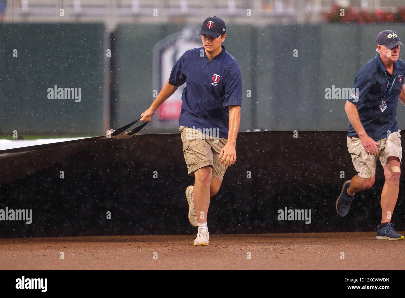 Minneapolis, Minnesota, USA. 18th June, 2024. Groundskeepers lay a tarp ...
